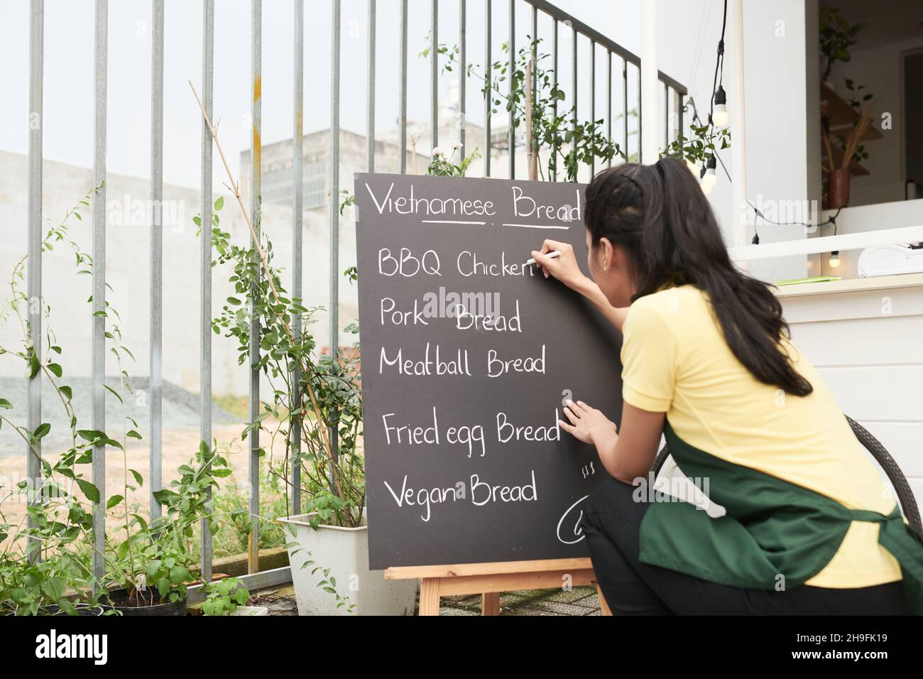 Street food bakery owner writing list of bread she bake and sell on ...