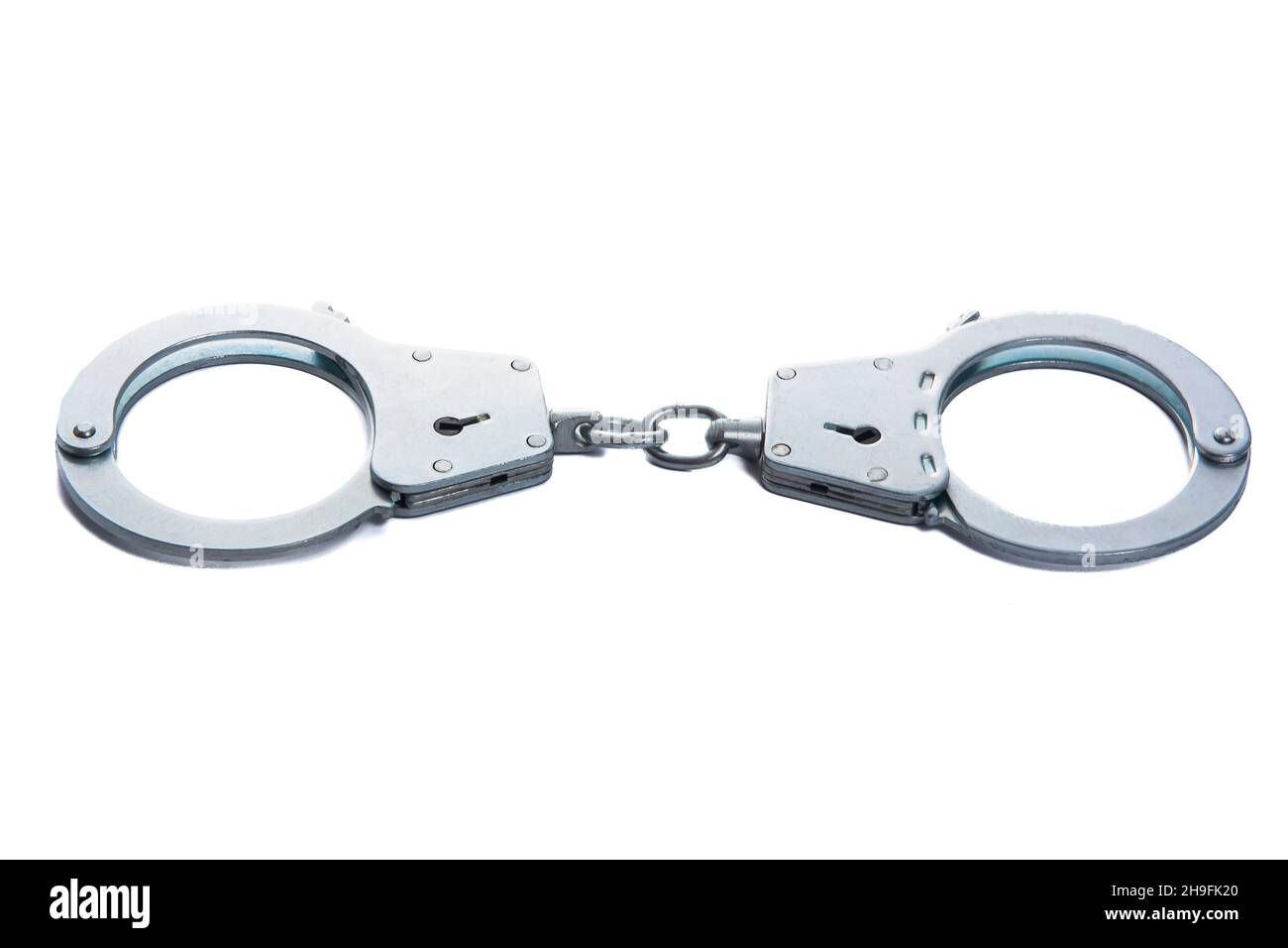 Metal handcuffs on a white isolated background Stock Photo - Alamy