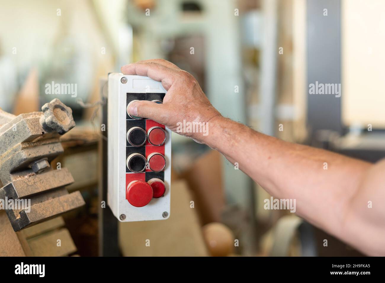 One person pushing a button in a wood factory Stock Photo - Alamy
