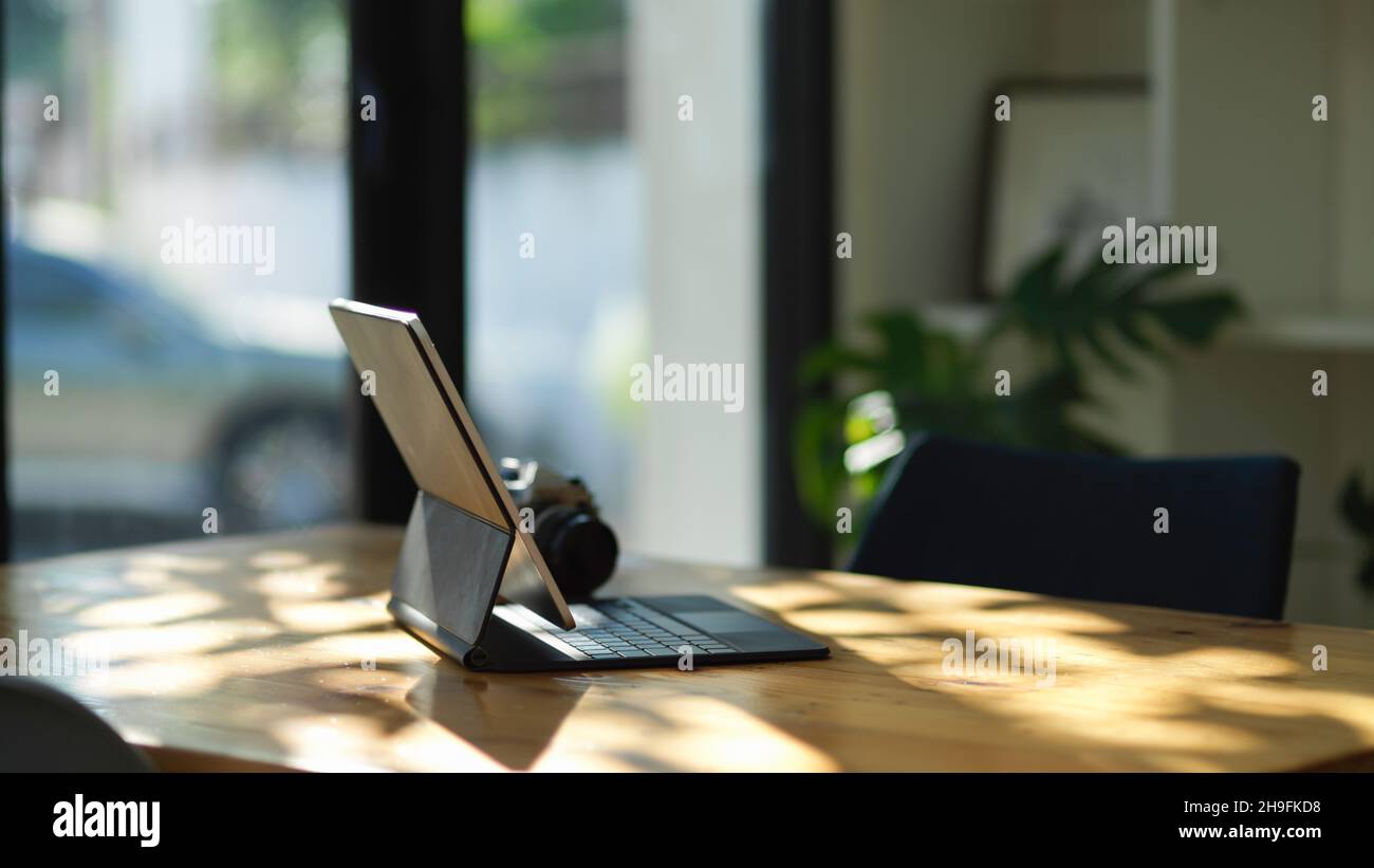 Side view image of a working desk with portable tablet computer and ...