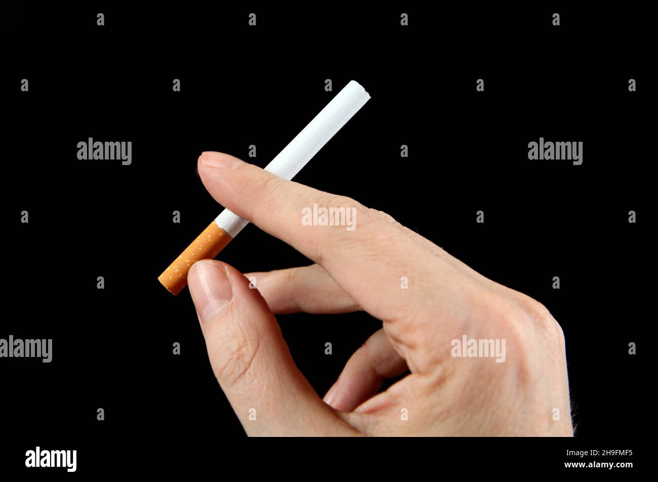 Cigarette in the Hand on the Black Background Stock Photo - Alamy