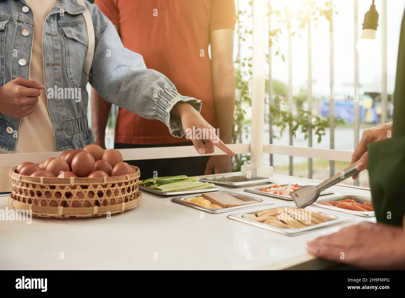 Female customer pointing at ingredient she want in her sandwich Stock ...