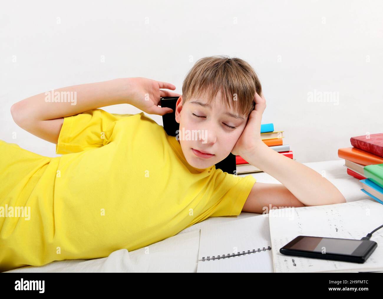 Tired Teenager doing Homework on the Sofa at the Home Stock Photo - Alamy