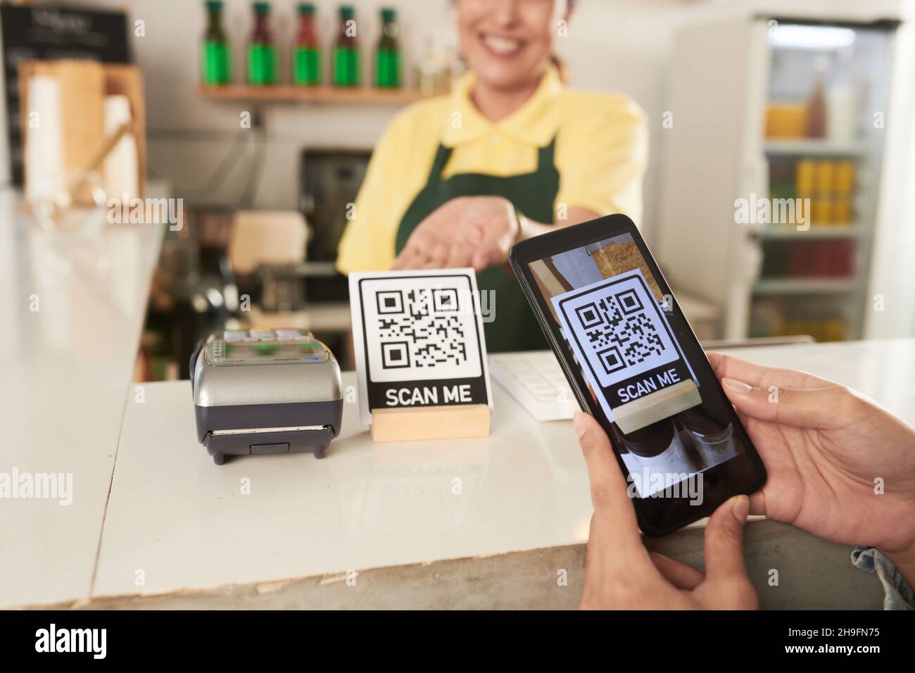 Hands of customer scanning QR code with smartphone to order take out ...