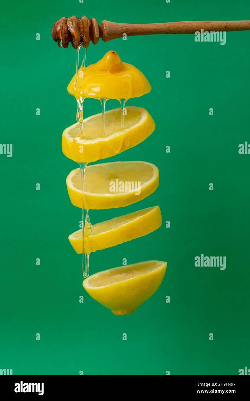 lemon slices levitating on a green background with honey drops Stock ...