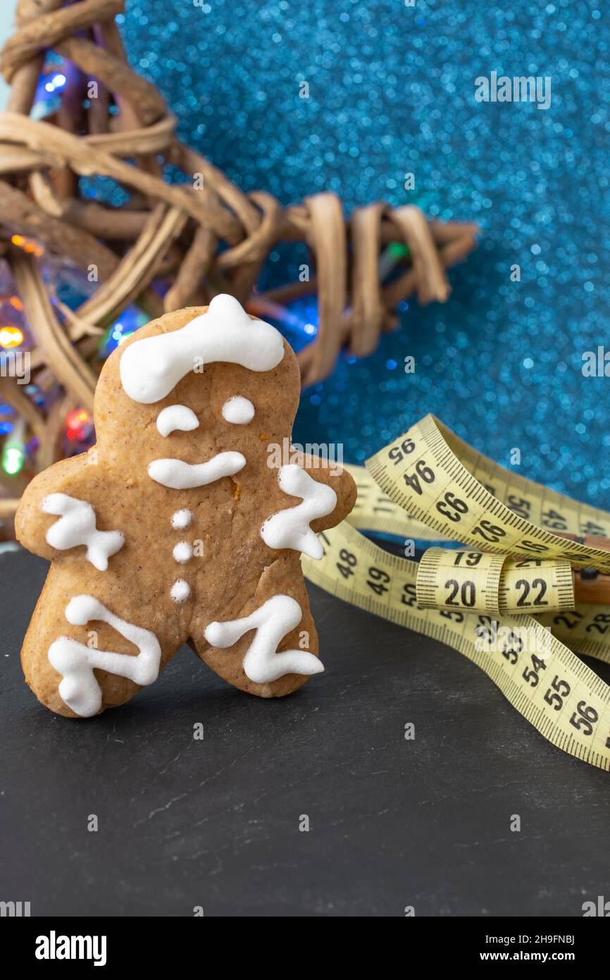 gingerbread man next to a tape measure on a black stone tile. New year ...