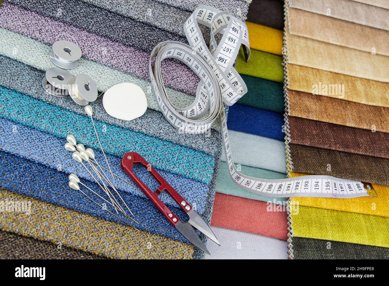 Pieces of cloth with scissors, needle and thread. Tailoring ...