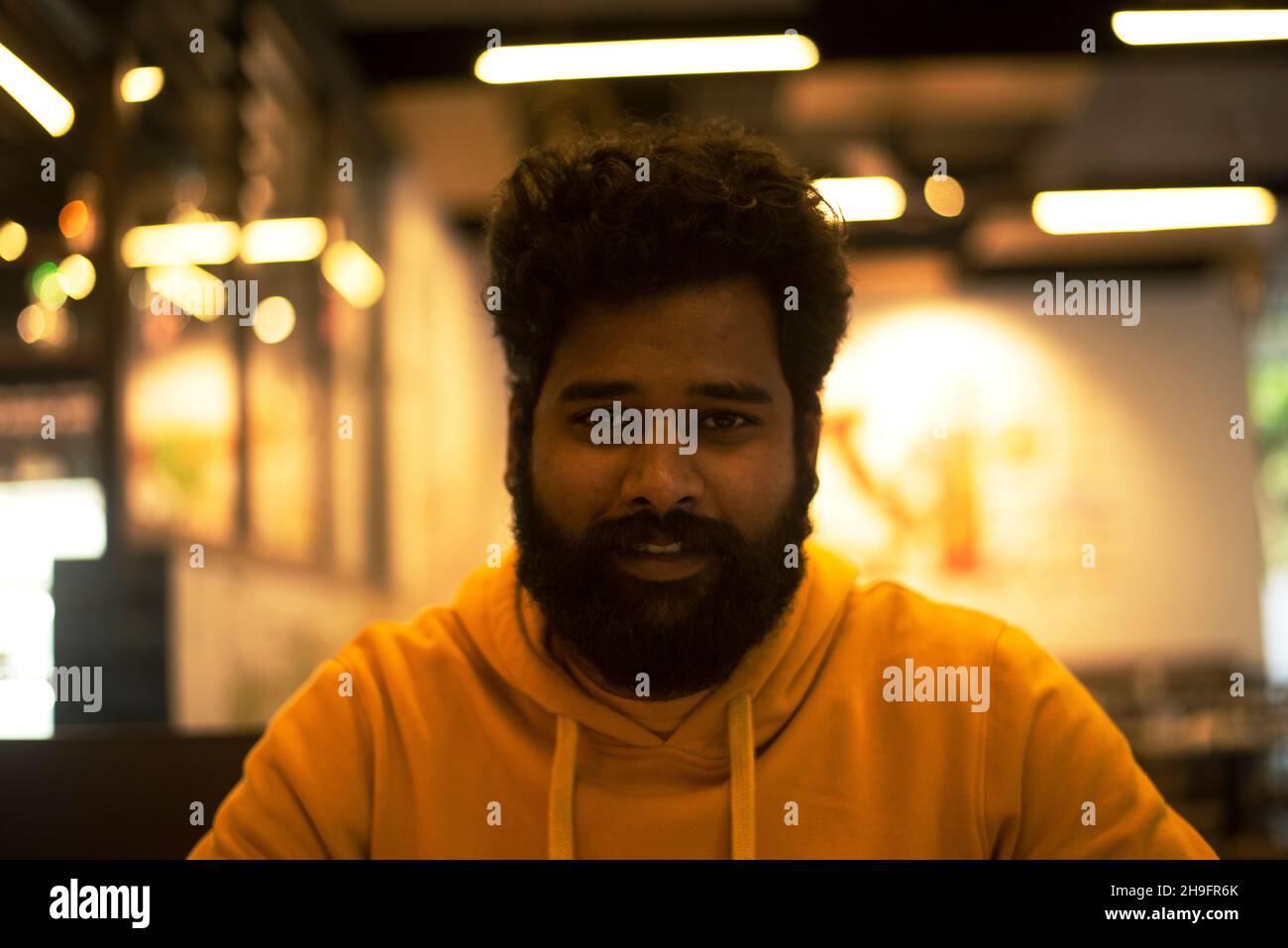 Handsome Indian guy waiting at a restaurant Stock Photo - Alamy