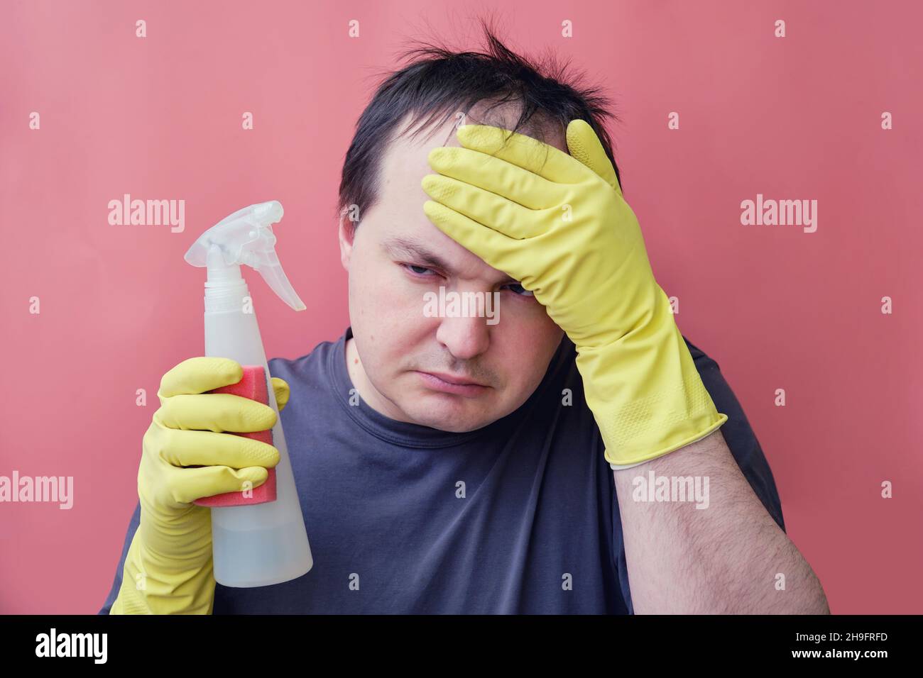 Sad man cleaner in yellow gloves, studio pink background Stock Photo ...