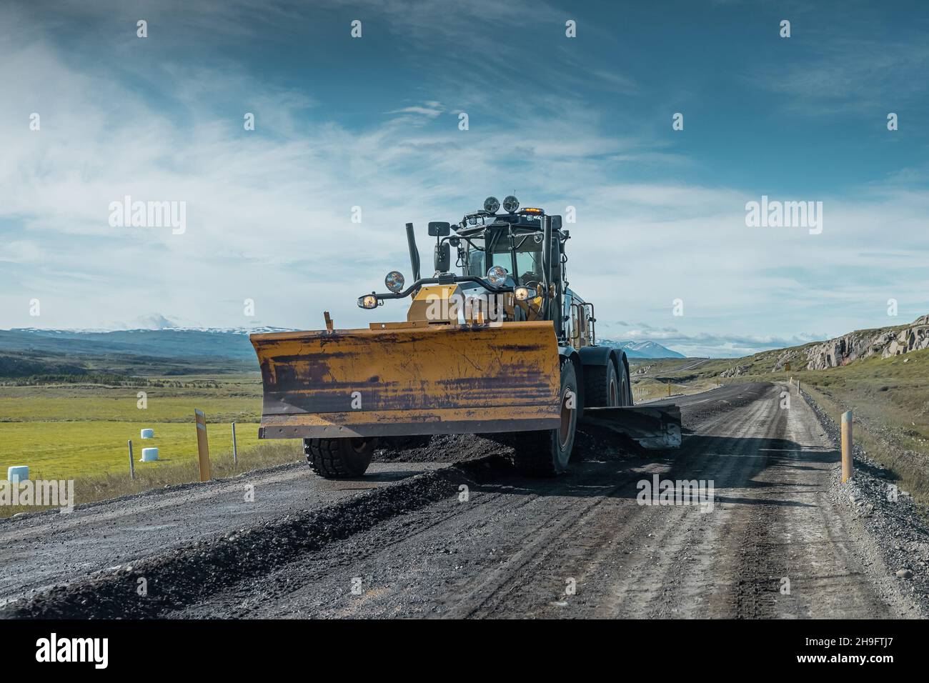 Grader grading or profiling gravel roads on Iceland. Routine ...