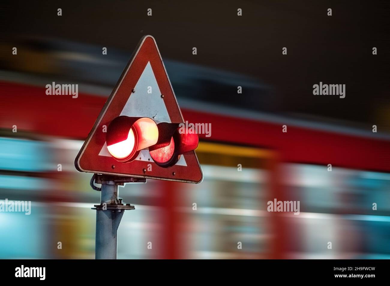 Passenger train rushing past the stop signal warning at night. Night ...