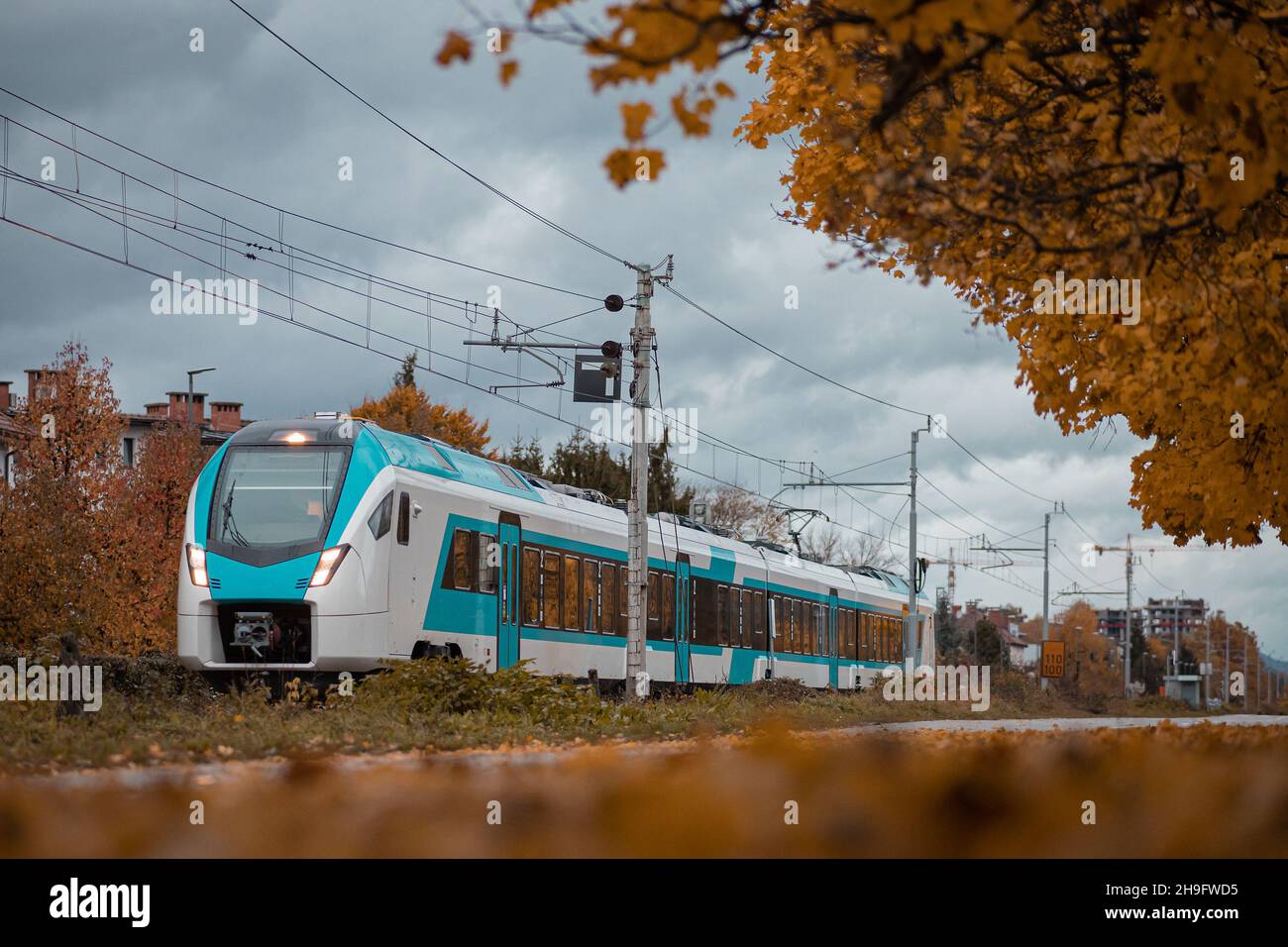 Early morning passenger train in blue and white color rushing towards ...