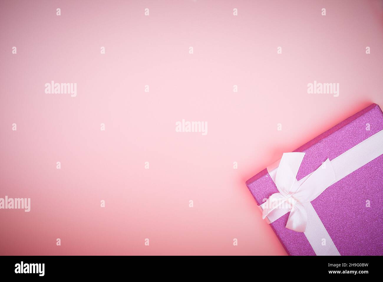 pink glitter gift box with ribbon on a pink background. minimalistic ...