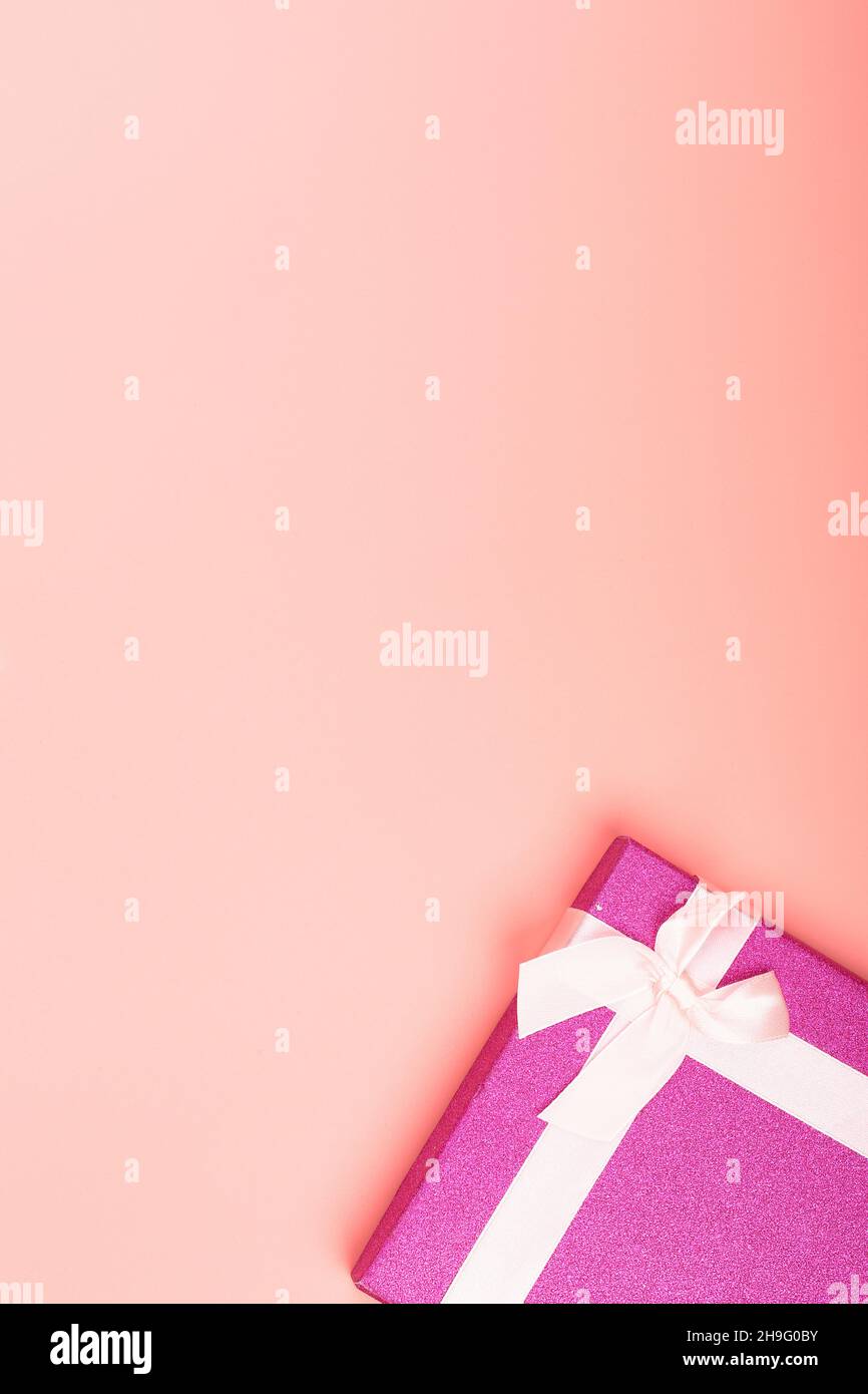 pink glitter gift box with ribbon on a pink background. minimalistic ...