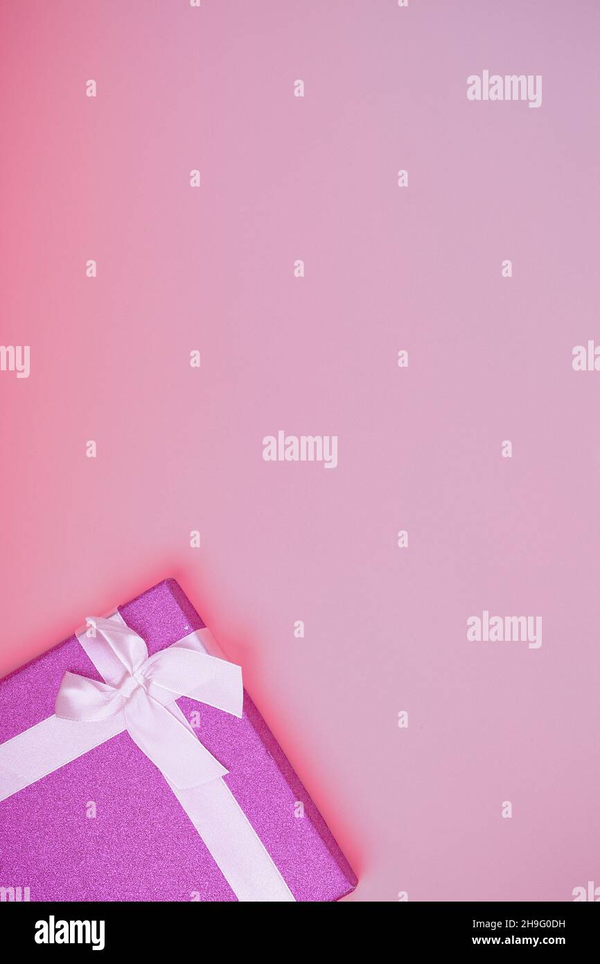 pink glitter gift box with ribbon on a pink background. minimalistic ...