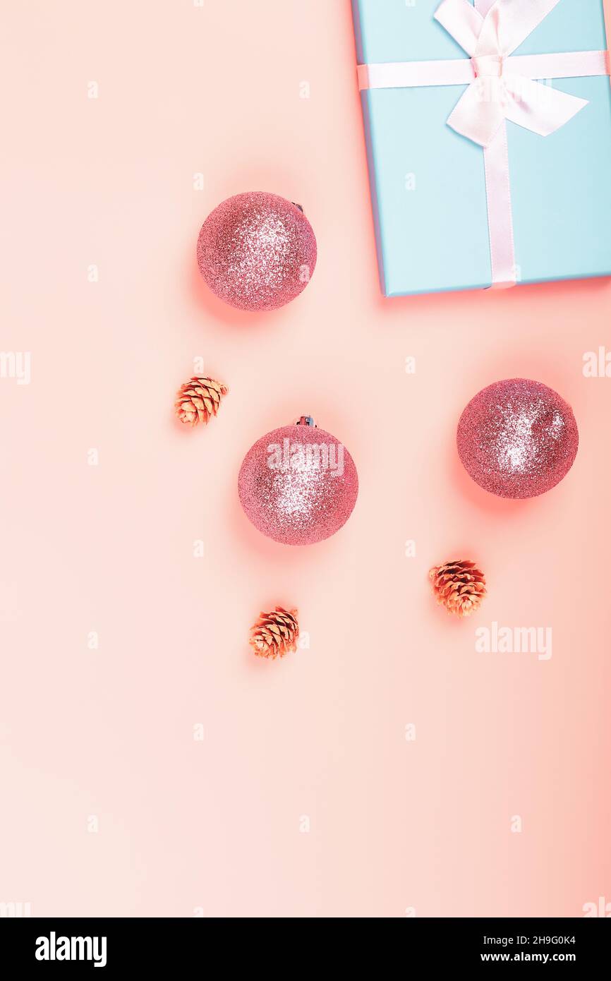 Blue glitter gift box with ribbon and Christmas toys on a pink ...