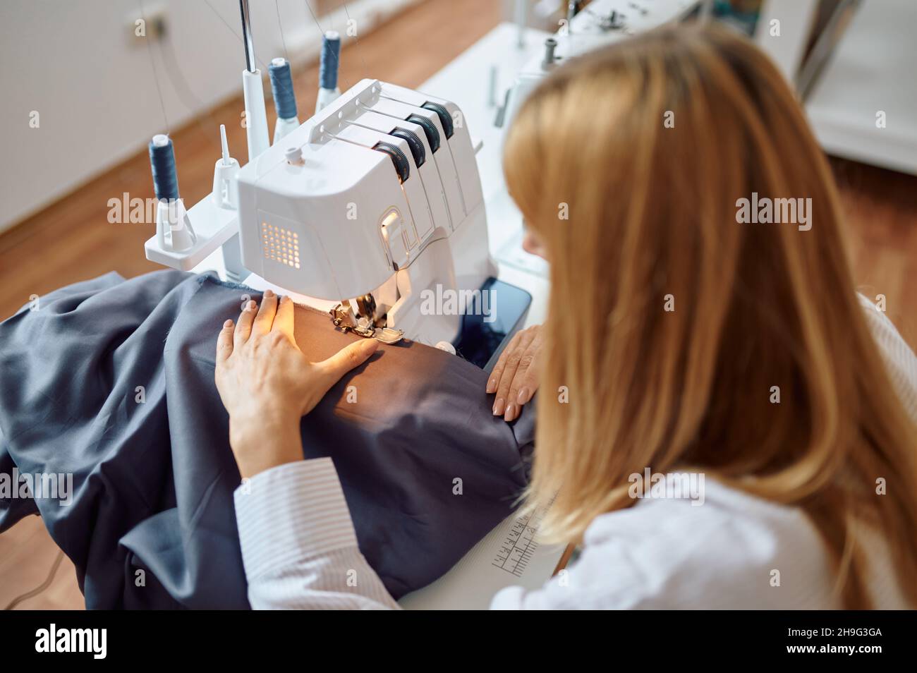 Dressmaker works on sewing machine at workplace Stock Photo - Alamy