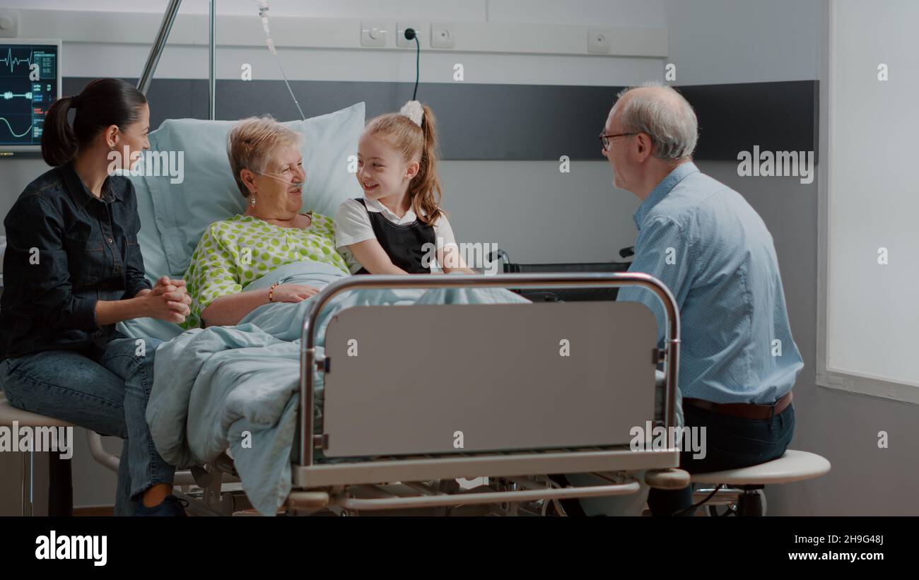 Kid hugging sick grandma at family visit in hospital ward. Mother ...