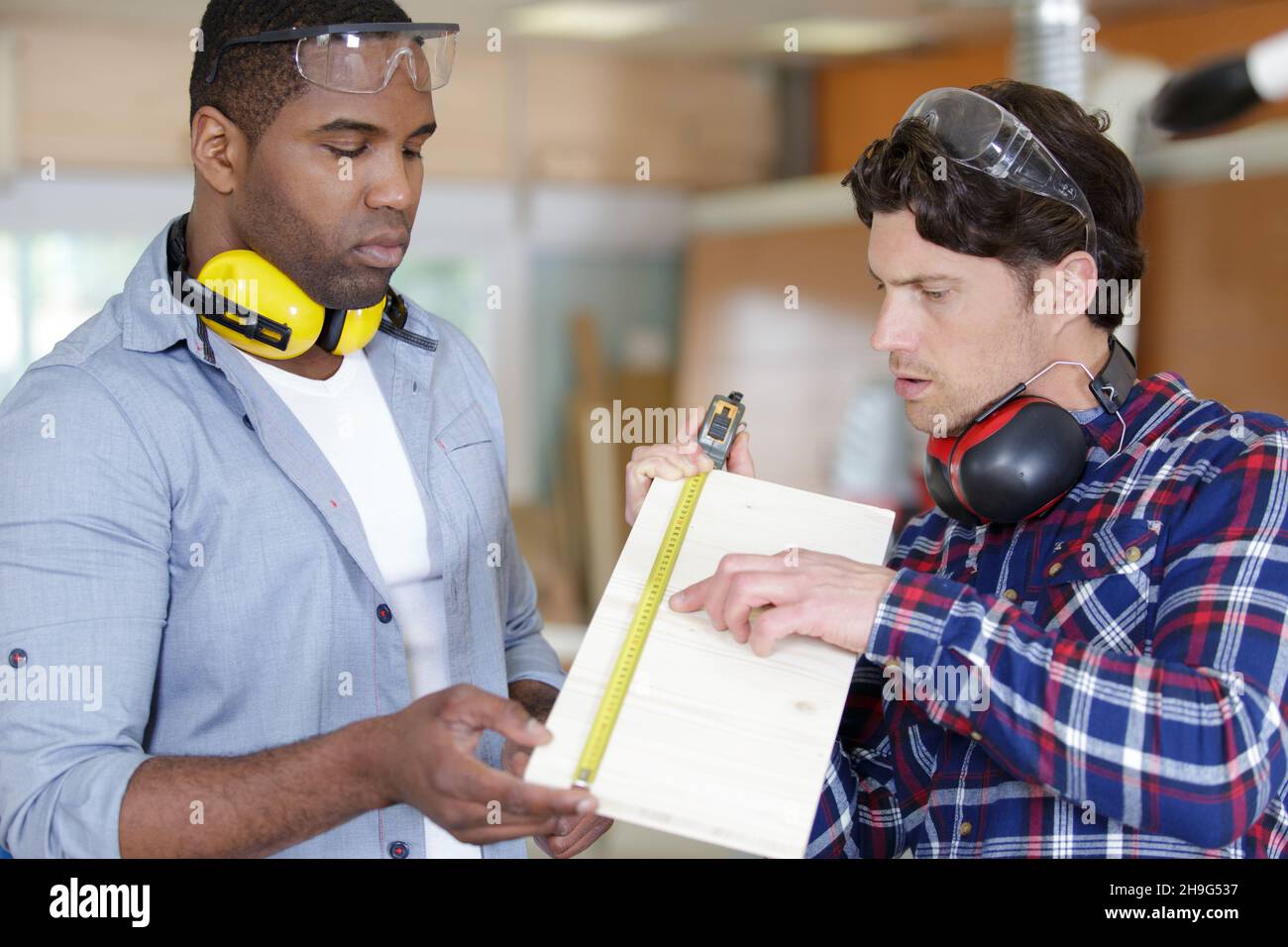 carpenter with female apprentice working on building site Stock Photo ...