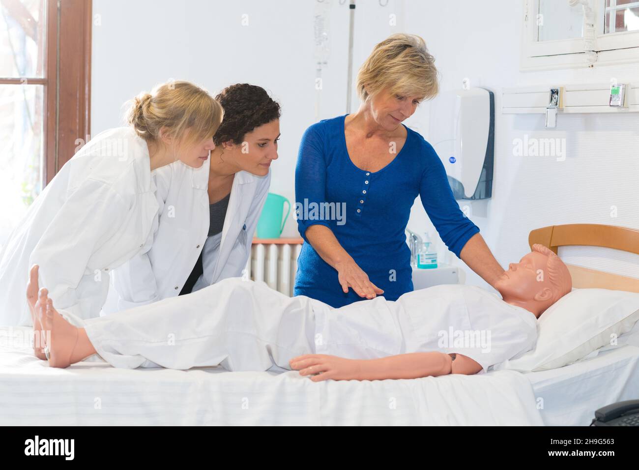 nurses training with dummy on bed Stock Photo - Alamy
