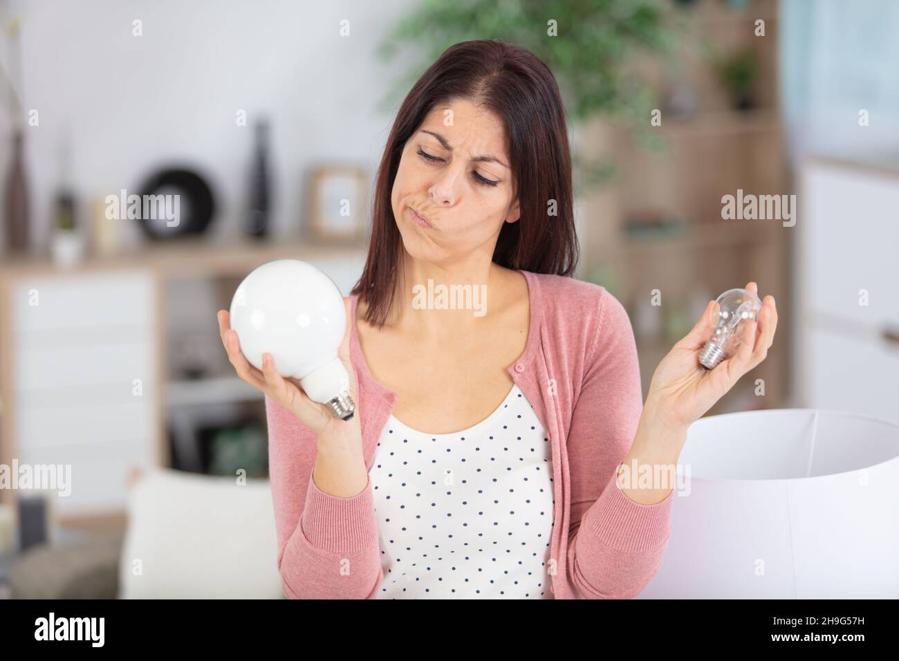 beautiful woman looking at light bulb Stock Photo - Alamy