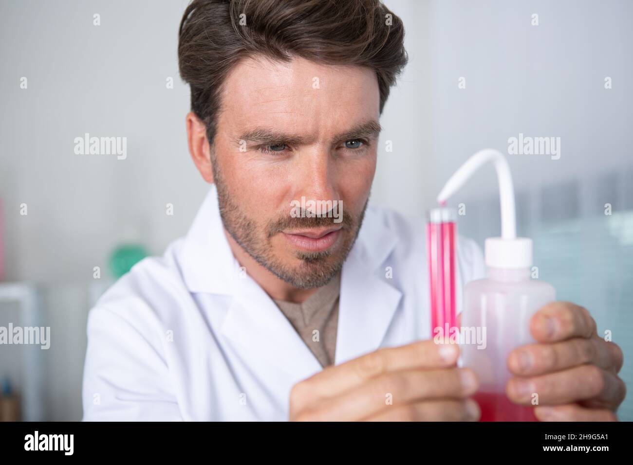 chemist man uses pipette to transfer liquids Stock Photo - Alamy