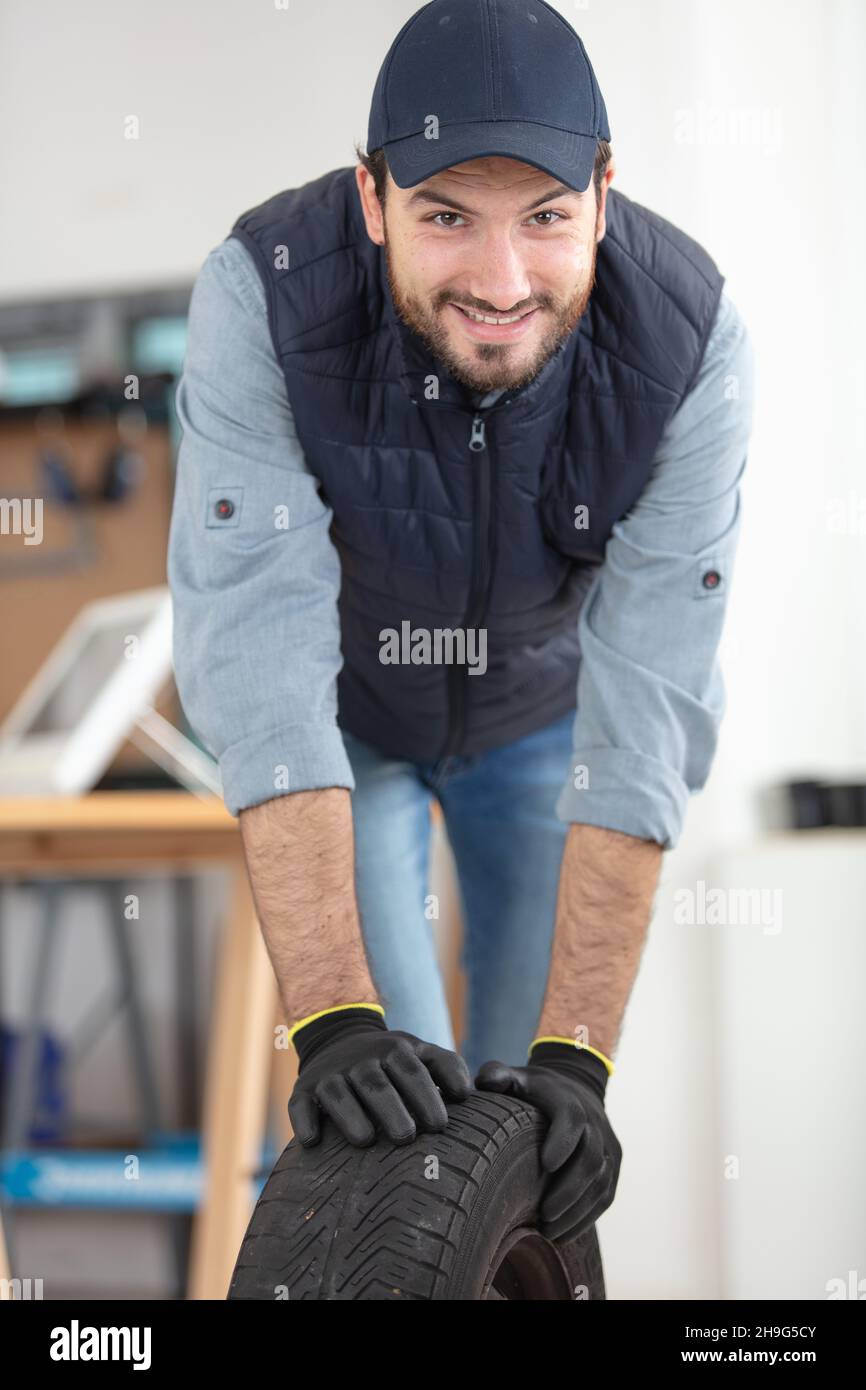 portrait of a mechanic replacing a wheel Stock Photo - Alamy