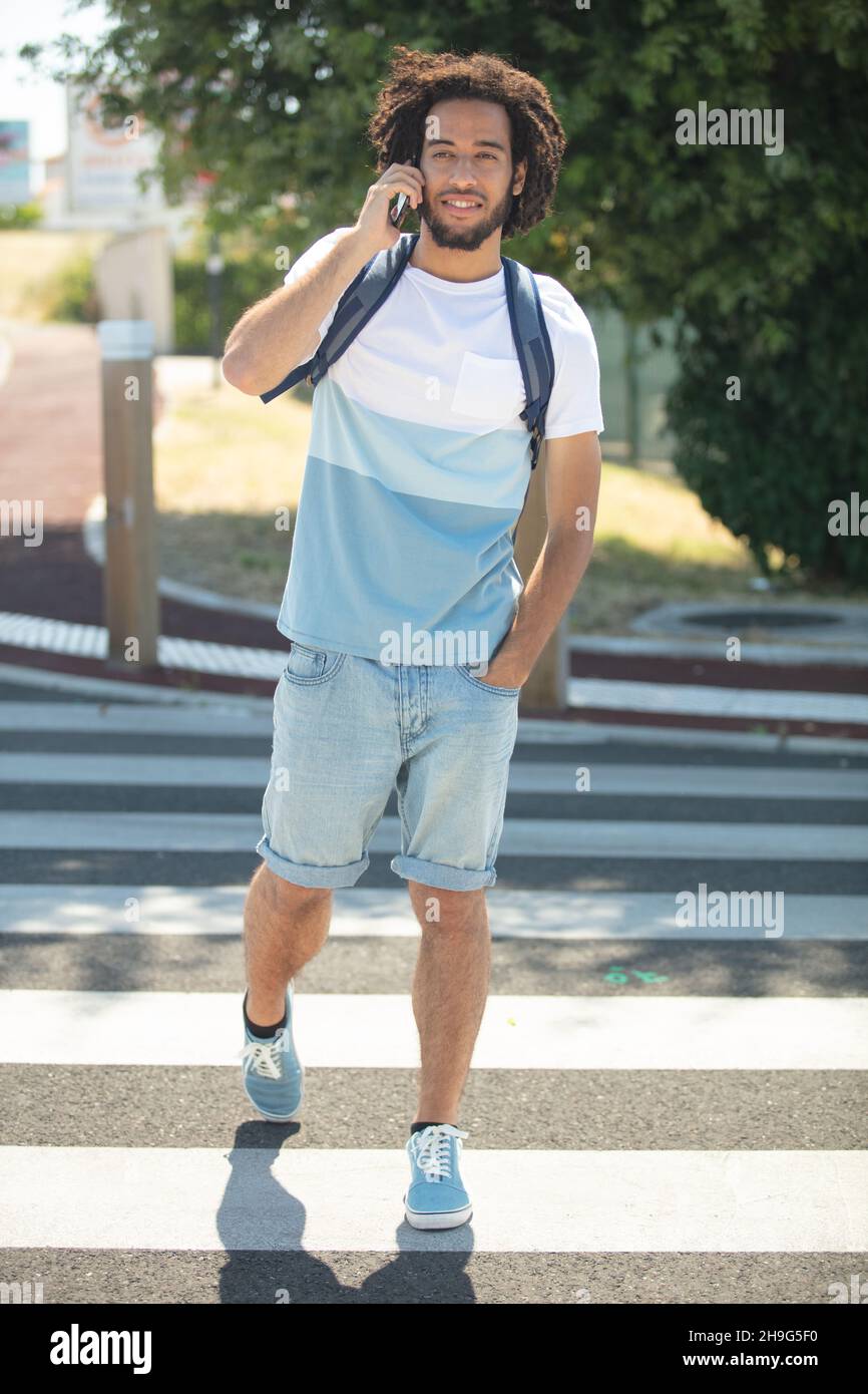 side view of young man crossing the street Stock Photo - Alamy