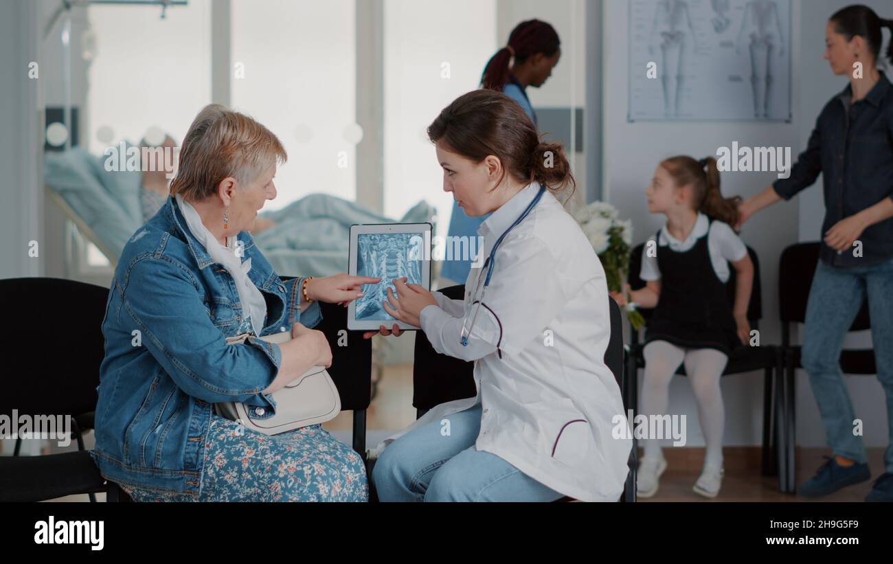 Close up of doctor and pensioner looking at x ray scan on digital ...