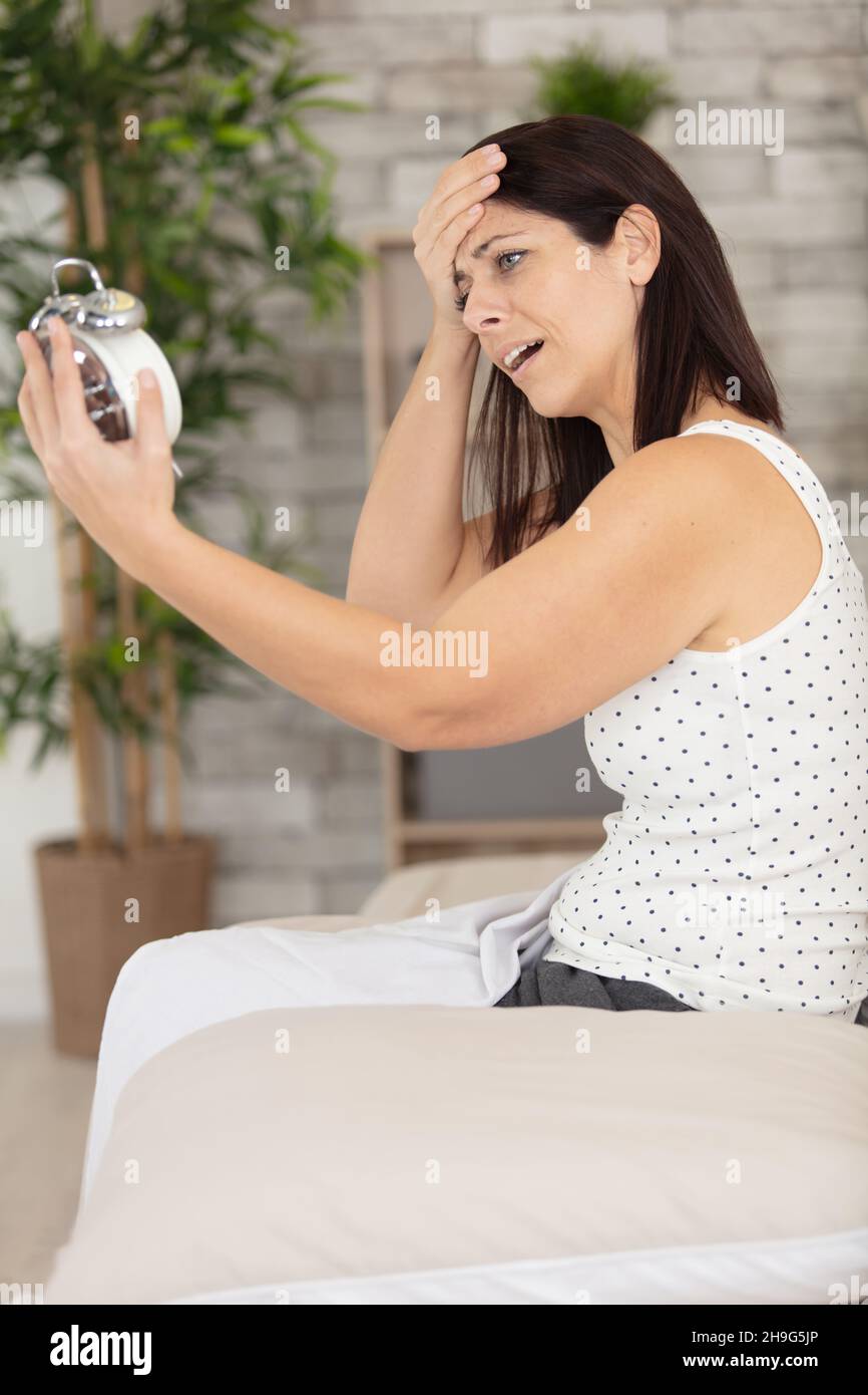 shocked young woman waking up with alarm Stock Photo - Alamy