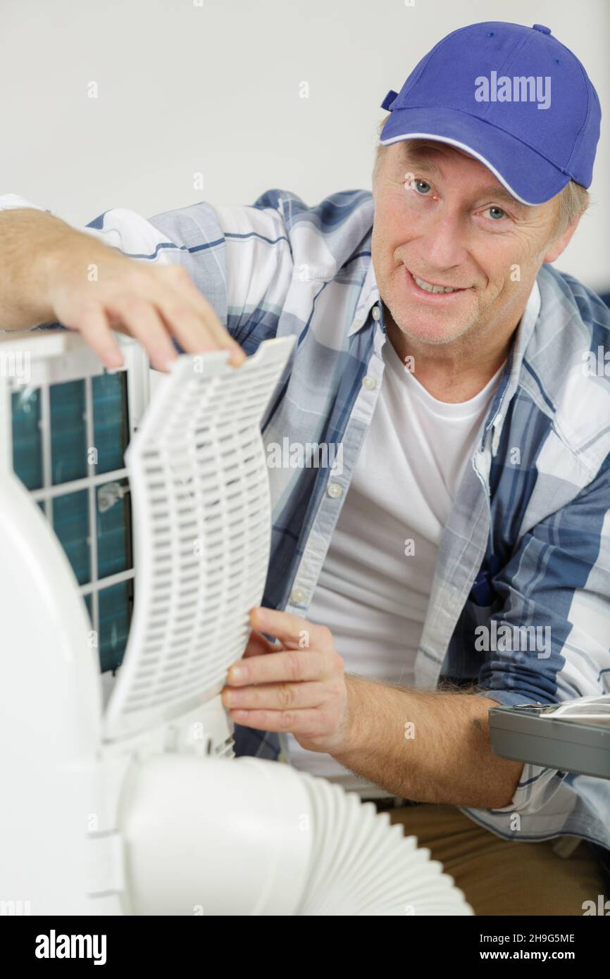mature man assembling an air conditioning unit Stock Photo - Alamy