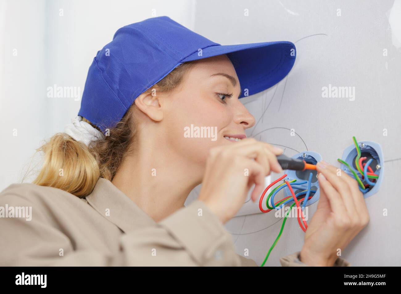Female electrician fixing socket hi-res stock photography and images ...