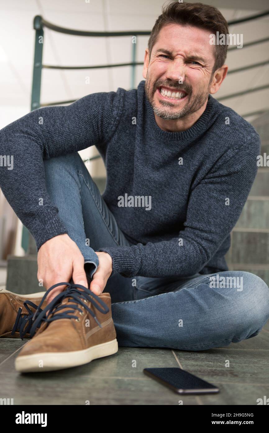 man sufferng an ankle injury after a fall dows stairs Stock Photo - Alamy