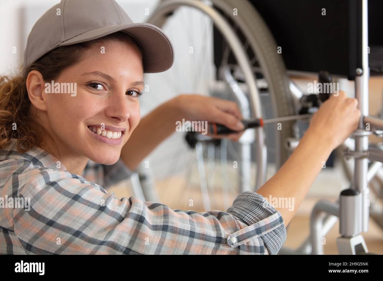 woman is repairing a wheelchair in garage Stock Photo - Alamy