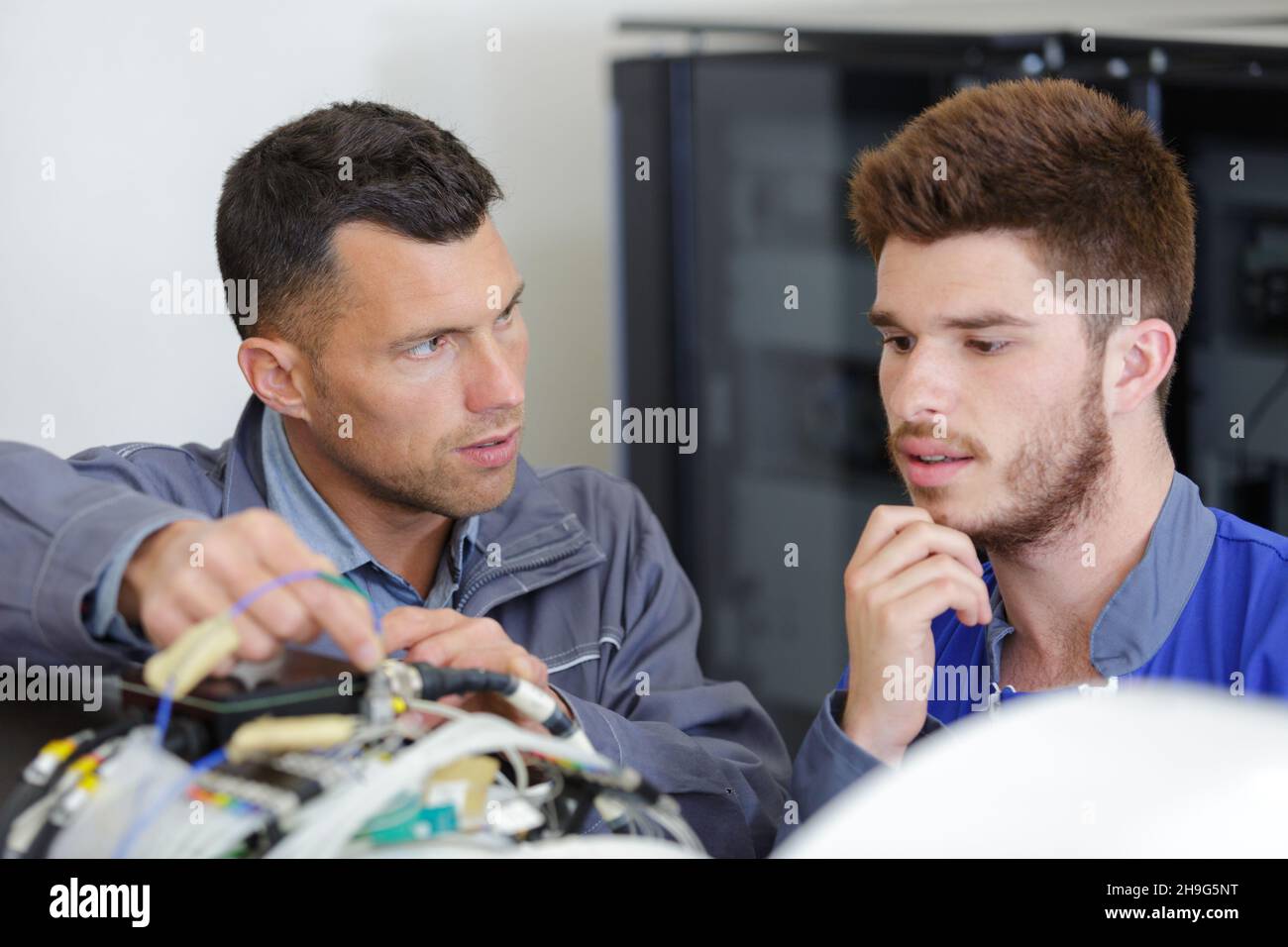 a male mechanic training apprentice Stock Photo - Alamy
