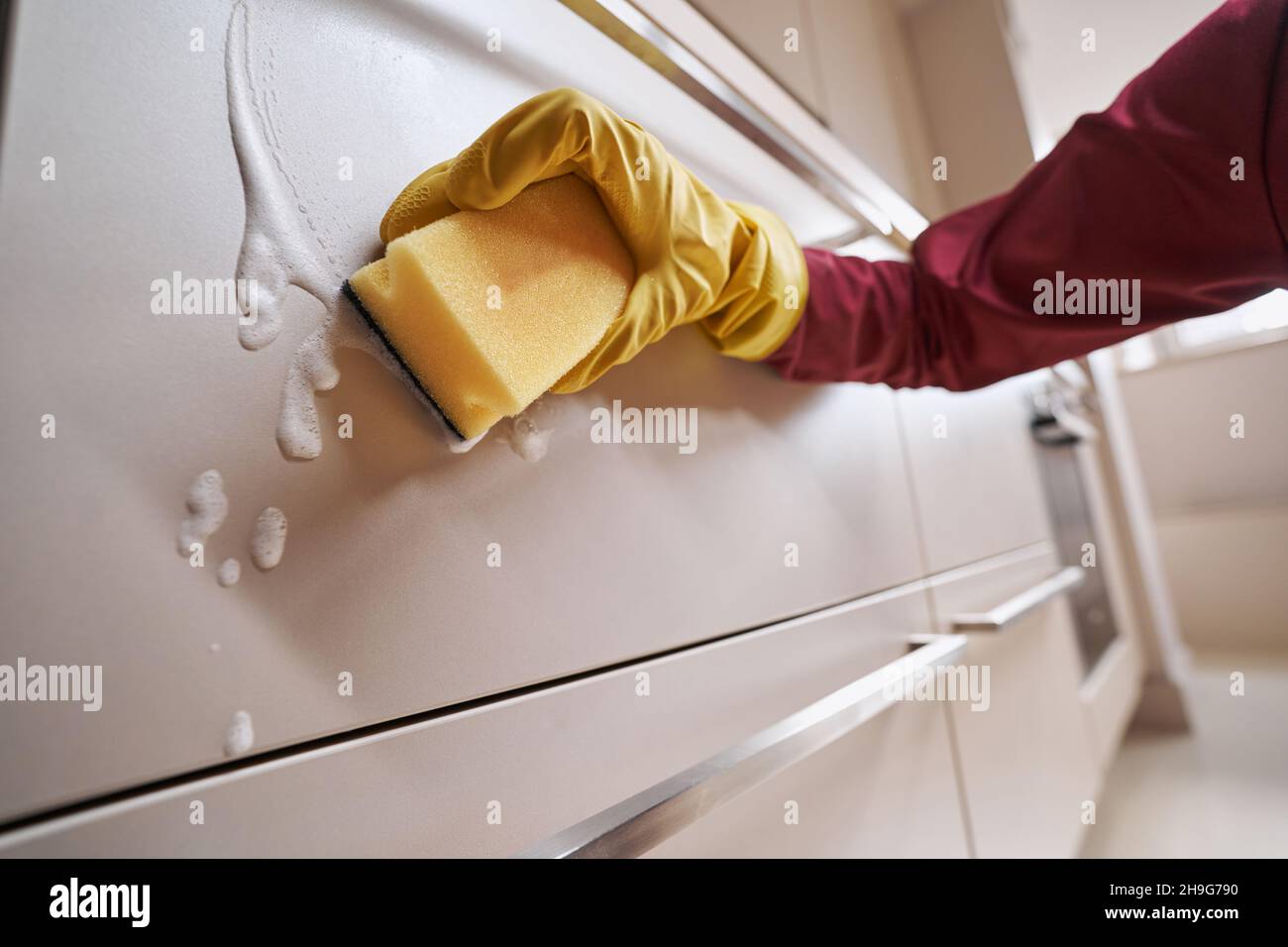 Janitor wiping down kitchen cabinet with cleaning solution Stock Photo ...