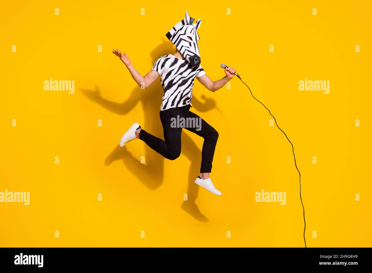 Full length photo of crazy weird guy rocker in zebra mask jump up sing ...