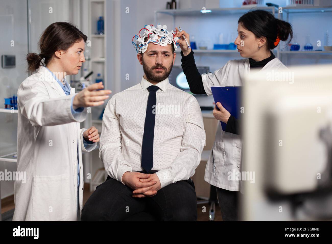 Medical team of scientists adjusting brain eeg analyzing nervous system ...