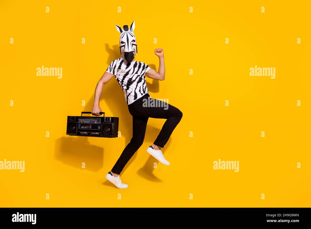Photo of eccentric cheerful man wear zebra print t-shirt mask listening ...