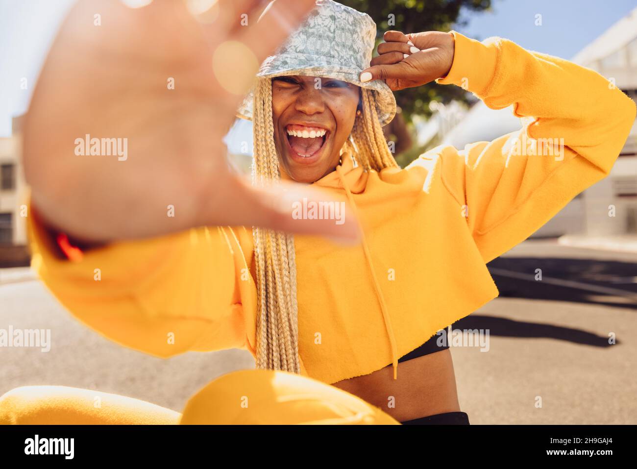 Young woman blocking the camera with her hand. Happy young woman ...