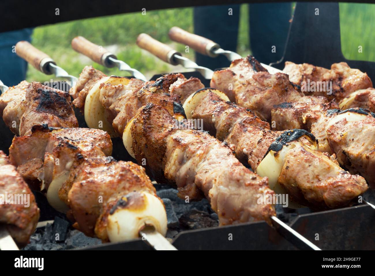Marinated shashlik preparing on a barbecue grill over charcoal ...