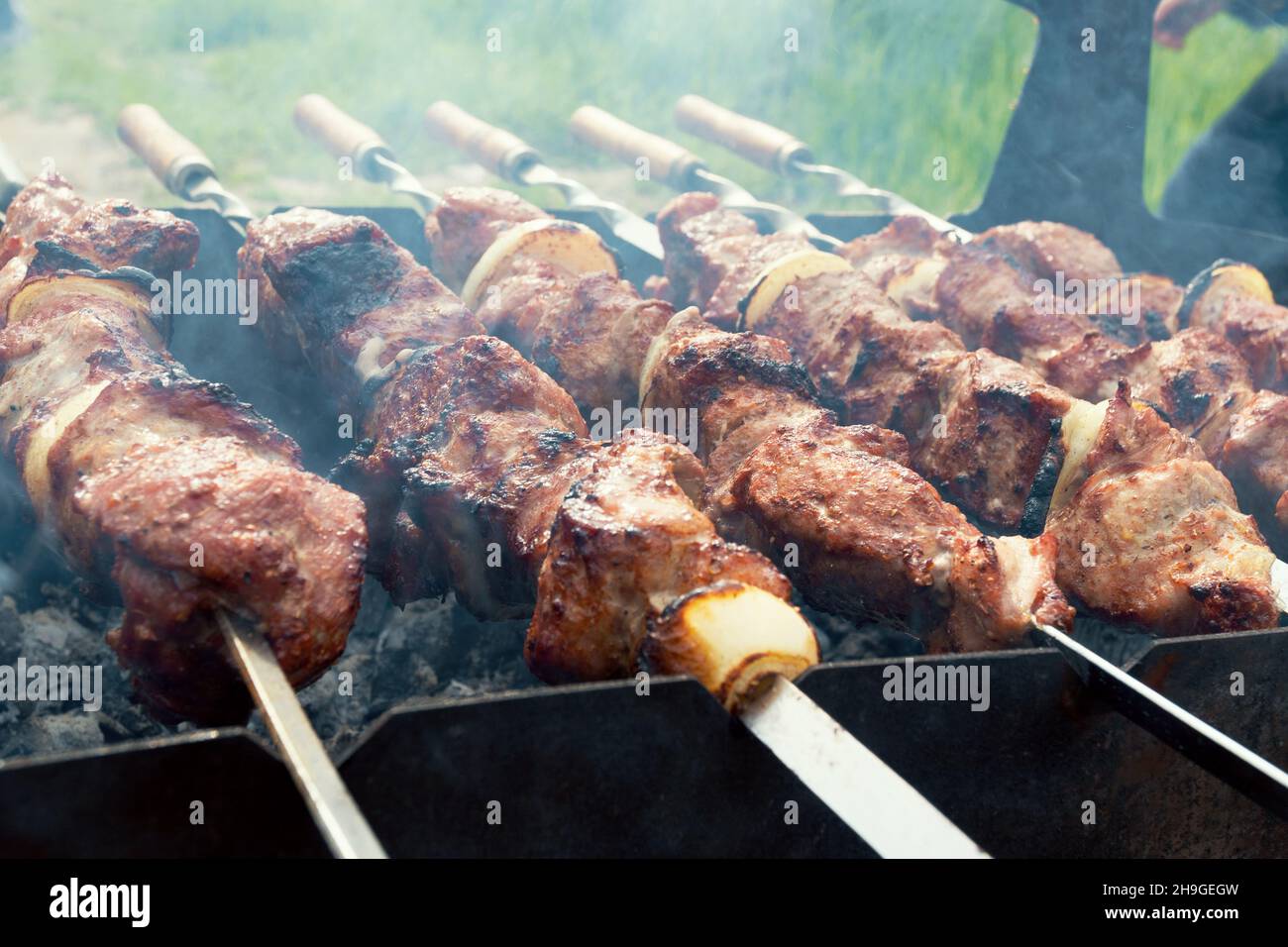 Marinated shashlik preparing on a barbecue grill over charcoal ...