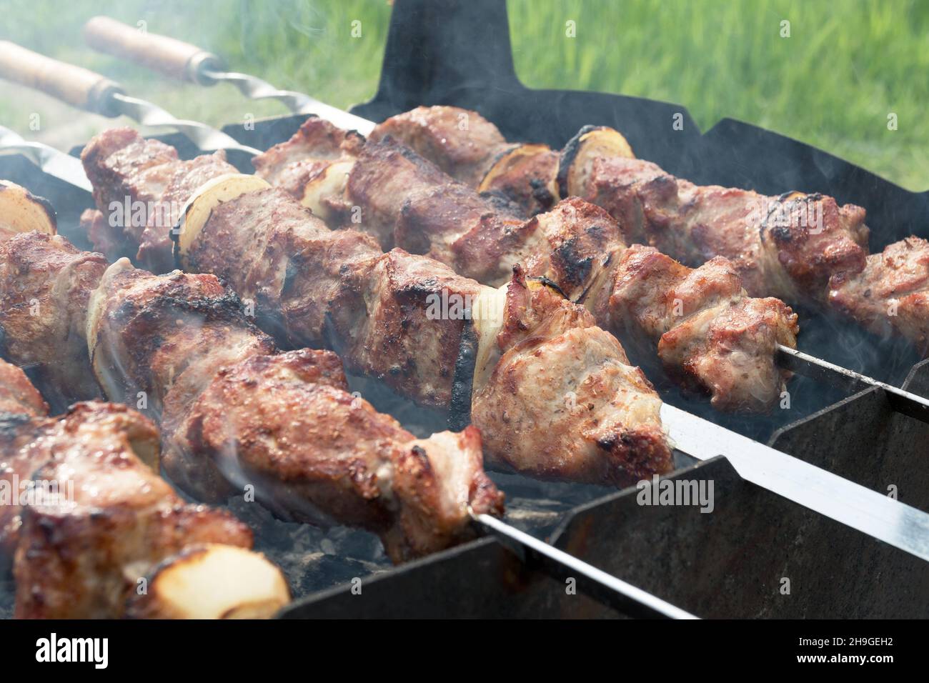 Marinated shashlik preparing on a barbecue grill over charcoal ...