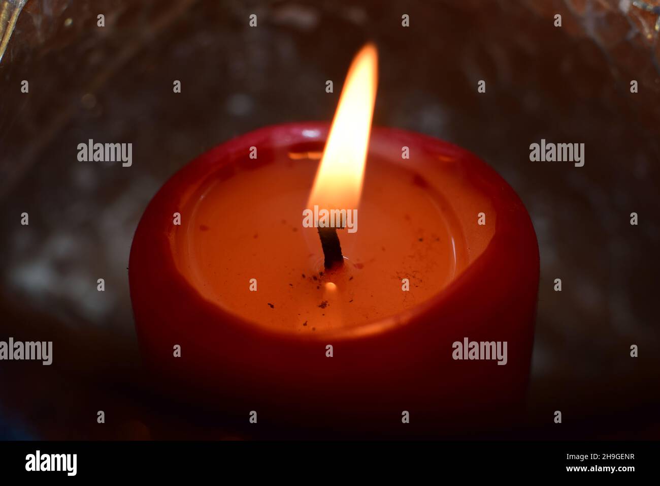 Burning red candle as a close up Stock Photo - Alamy