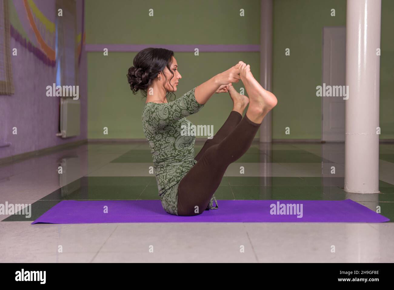 Yoga master demonstrating yoga asana in the gym Stock Photo - Alamy