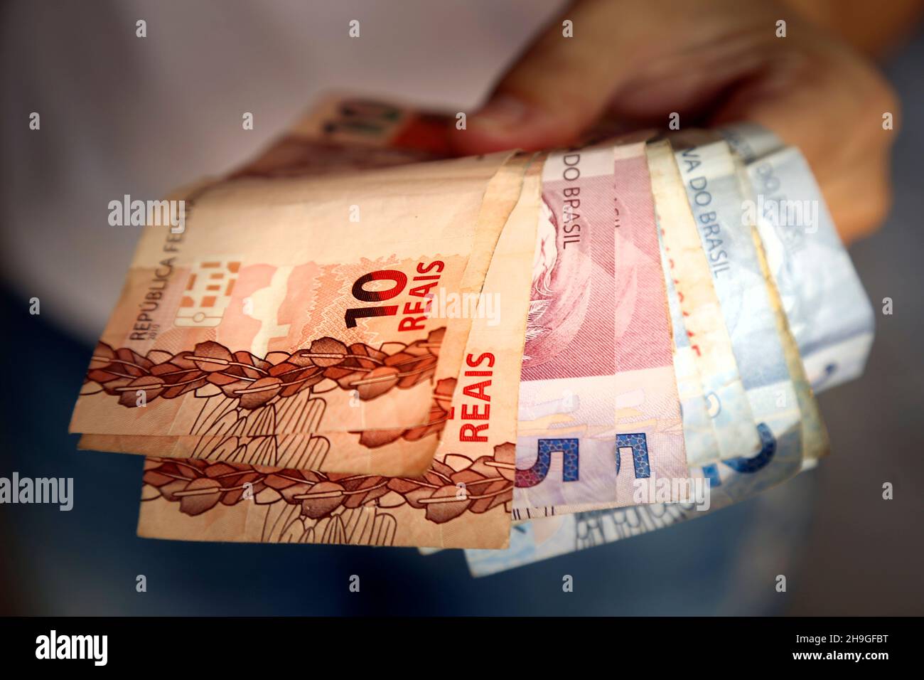 several Brazilian real notes in one hand Stock Photo - Alamy