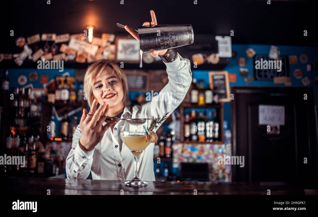 Focused girl bartender surprises with its skill bar visitors in cocktail bars Stock Photo - Alamy