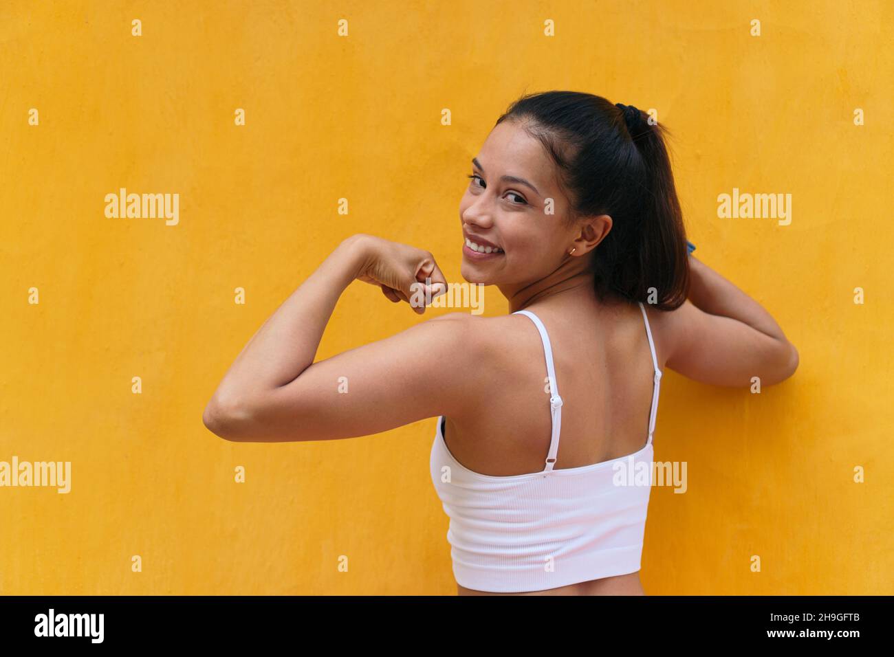 Latin woman flexing her muscles in the open air Stock Photo - Alamy
