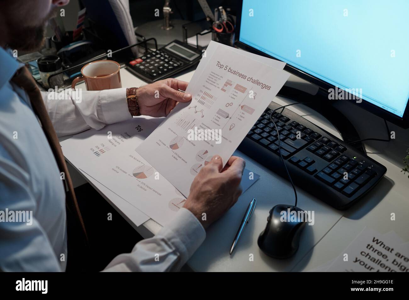 Hands of young businessman holding financial documents while sitting by ... Hands of young businessman holding financial documents while sitting by ...