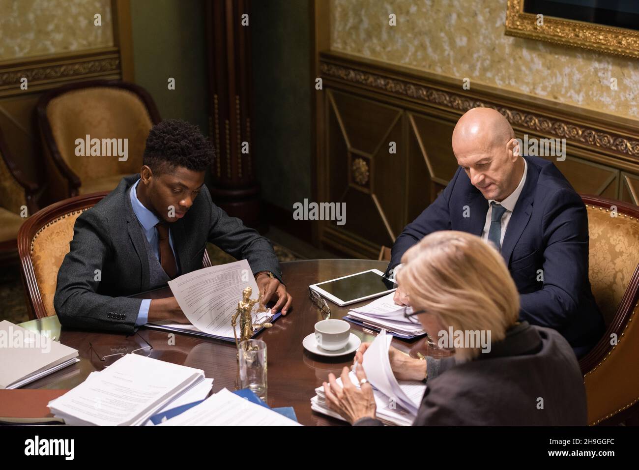 Group of contemporary intercultural lawyers looking through papers ...